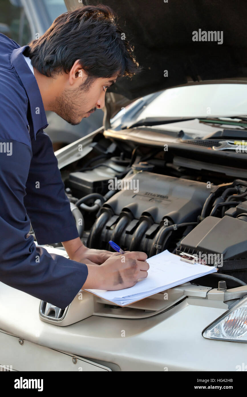 Car mechanic writing on clipboard Stock Photo - Alamy