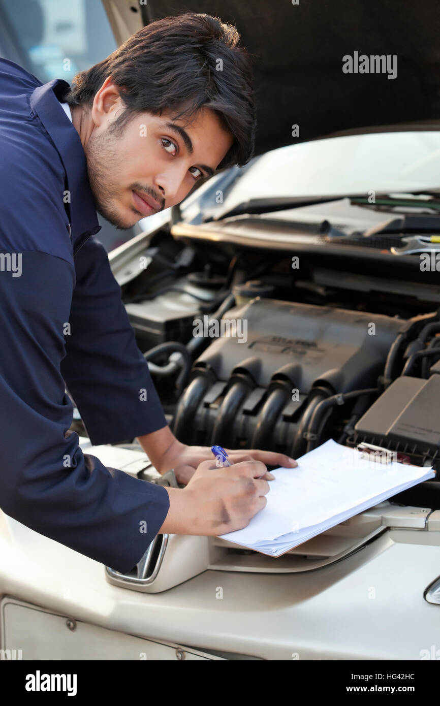Car mechanic writing on clipboard Car mechanic writing on clipboard ...