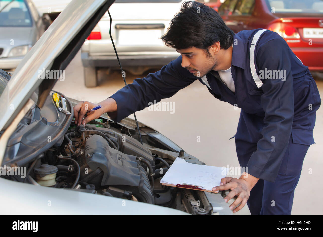 Car mechanic examining engine Stock Photo - Alamy
