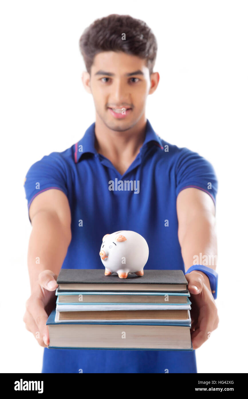 young college student holding stack of books with a small piggy bank ...