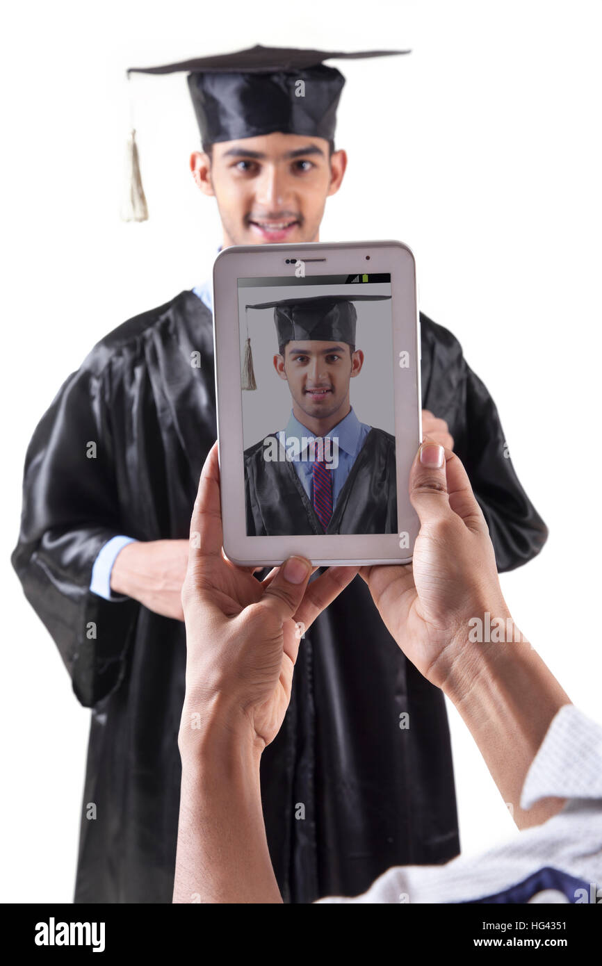 Friend taking picture of college graduate Stock Photo - Alamy