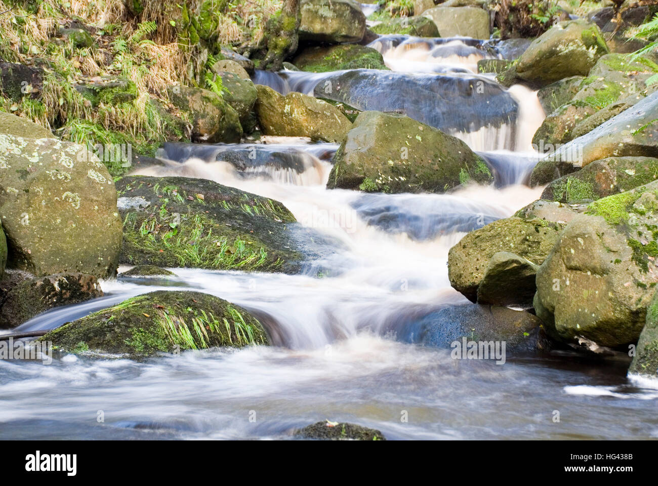 Close up on the fast flowing water of Burbage Brook in the rocky river ...