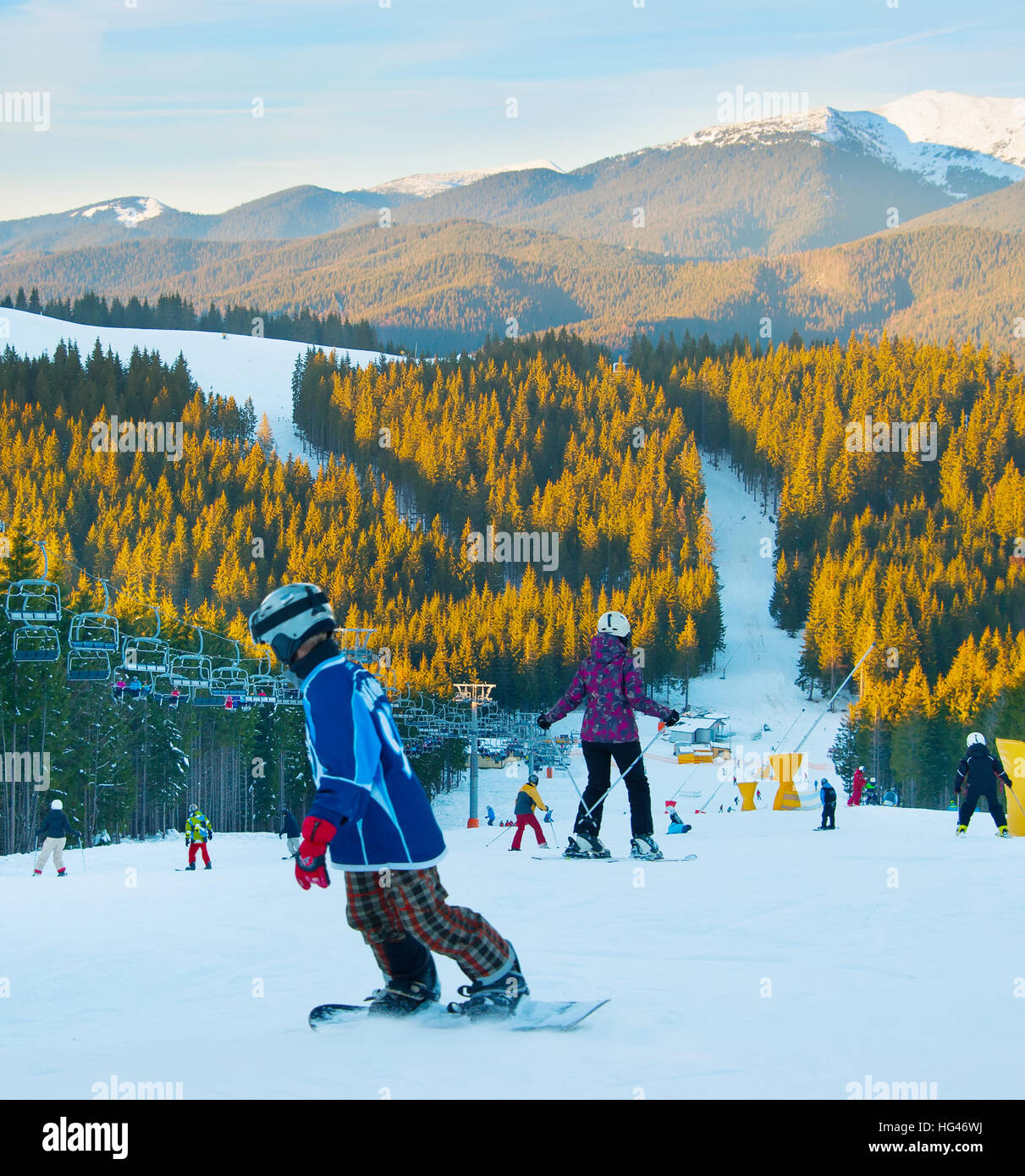Snowboarders and skiers on a mountains slope at ski resort Stock Photo ...