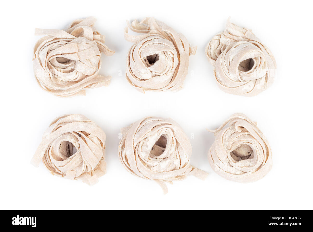 Homemade rolled traditional Italian pasta tagliatelle in row isolated ...