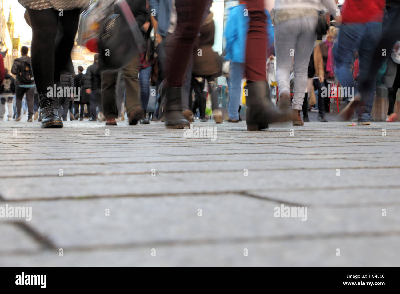 Legs of people walking along a busy shopping street, with motion blur ...