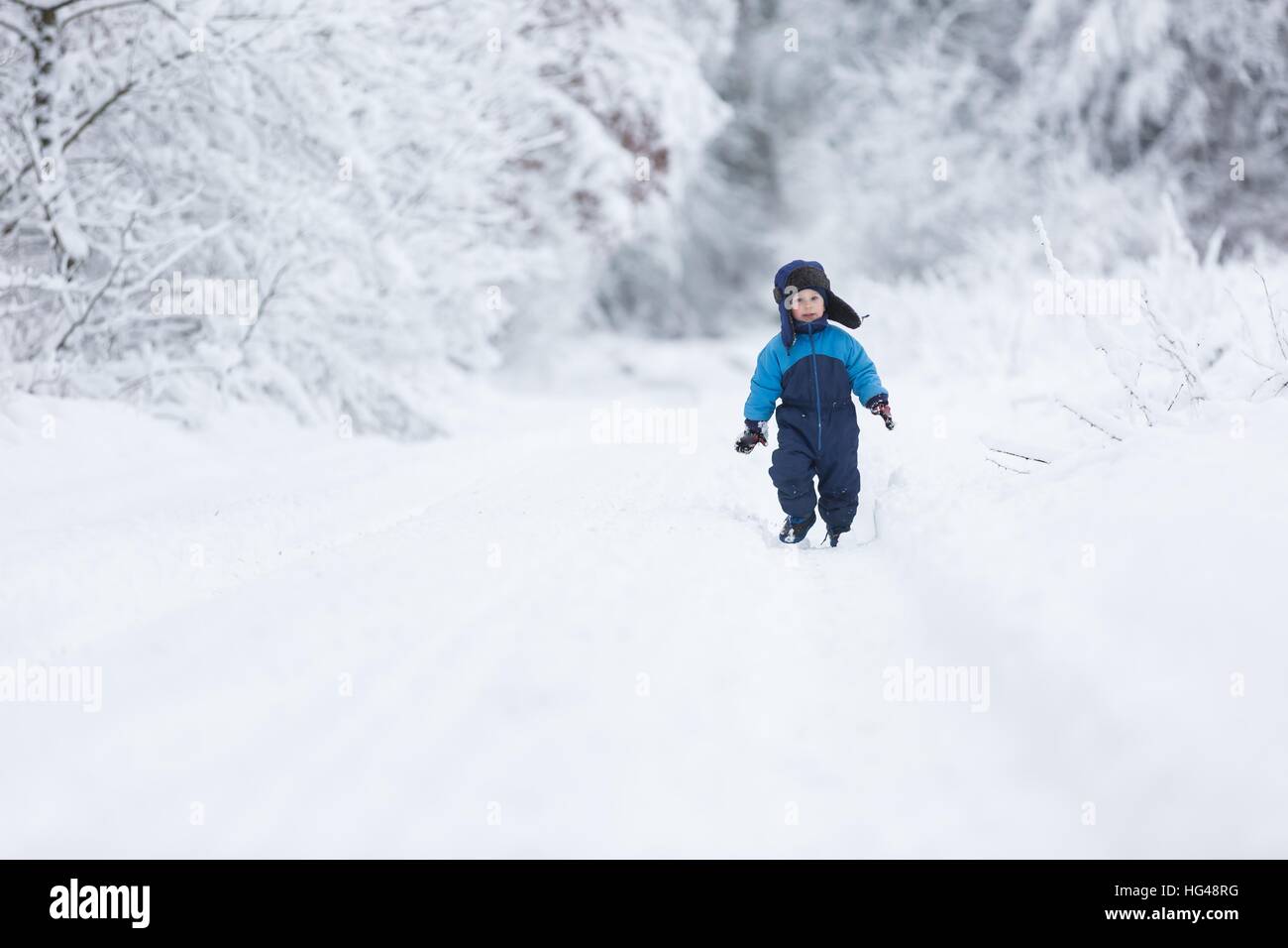Boy playing in big snow in winter. Happy caucasian child playing in ...
