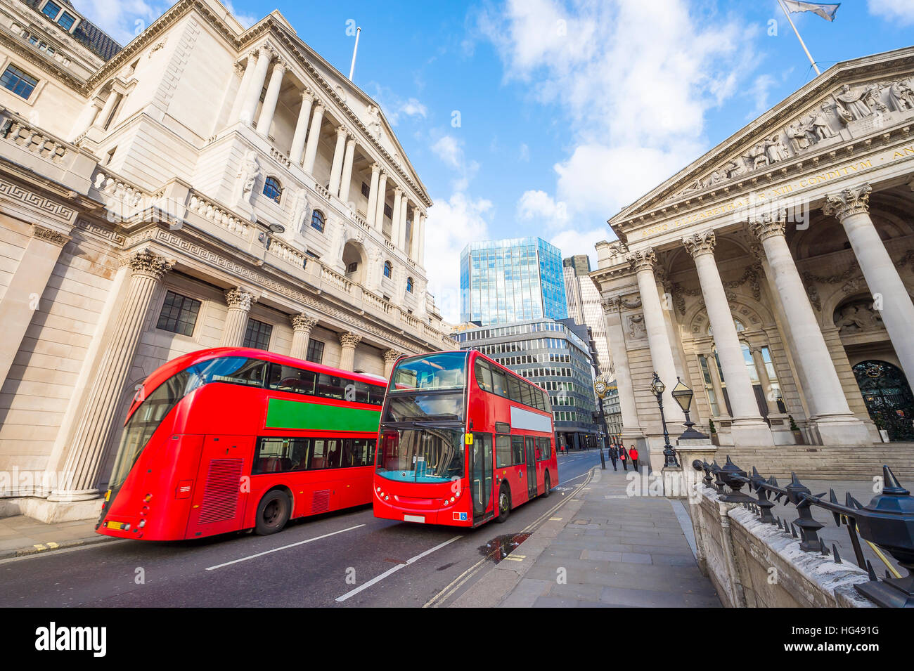 Modern red double decker buses pass through the traditional financial ...