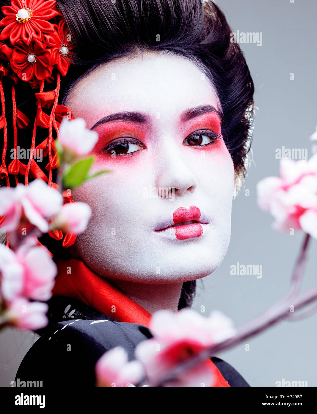 young pretty geisha in black kimono among sakura, asian ethno Stock ...