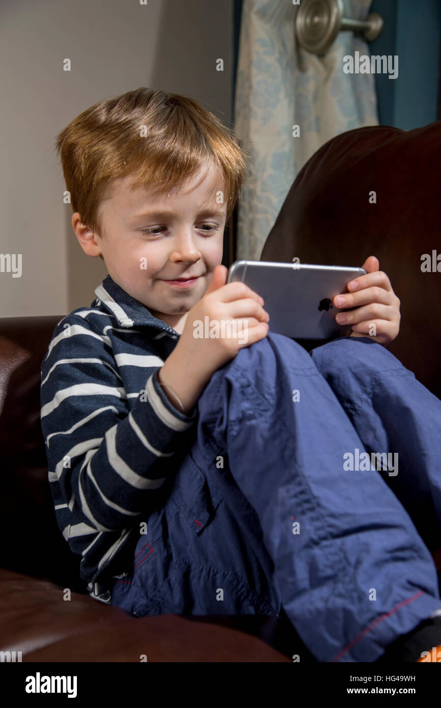 Kid boy child using phone sofa hi-res stock photography and images - Alamy