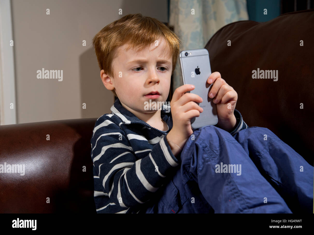 Child using technology. 5 year old boy with a smart phone or iPhone ...