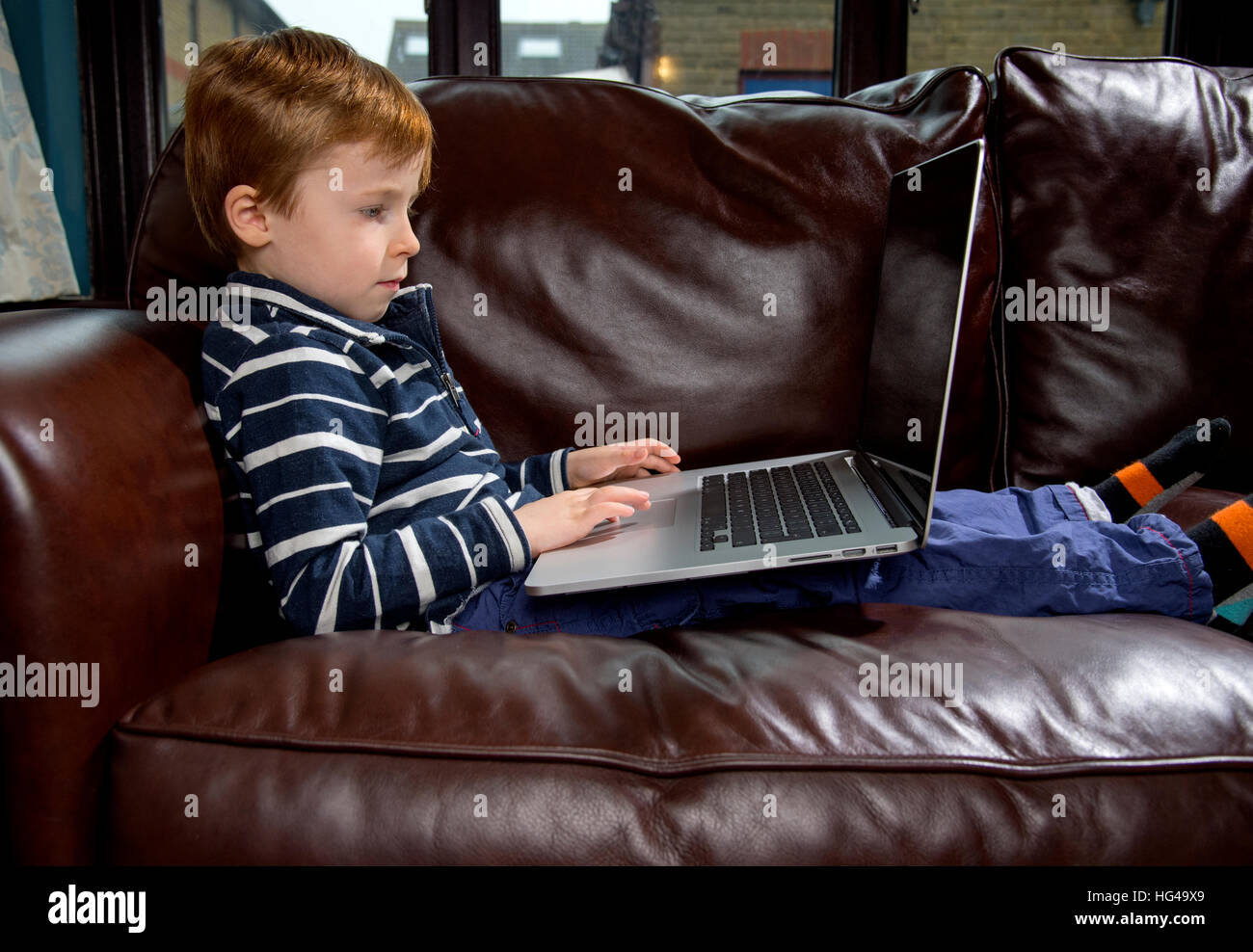 Child using technology. 5 year old boy with a laptop computer Stock ...