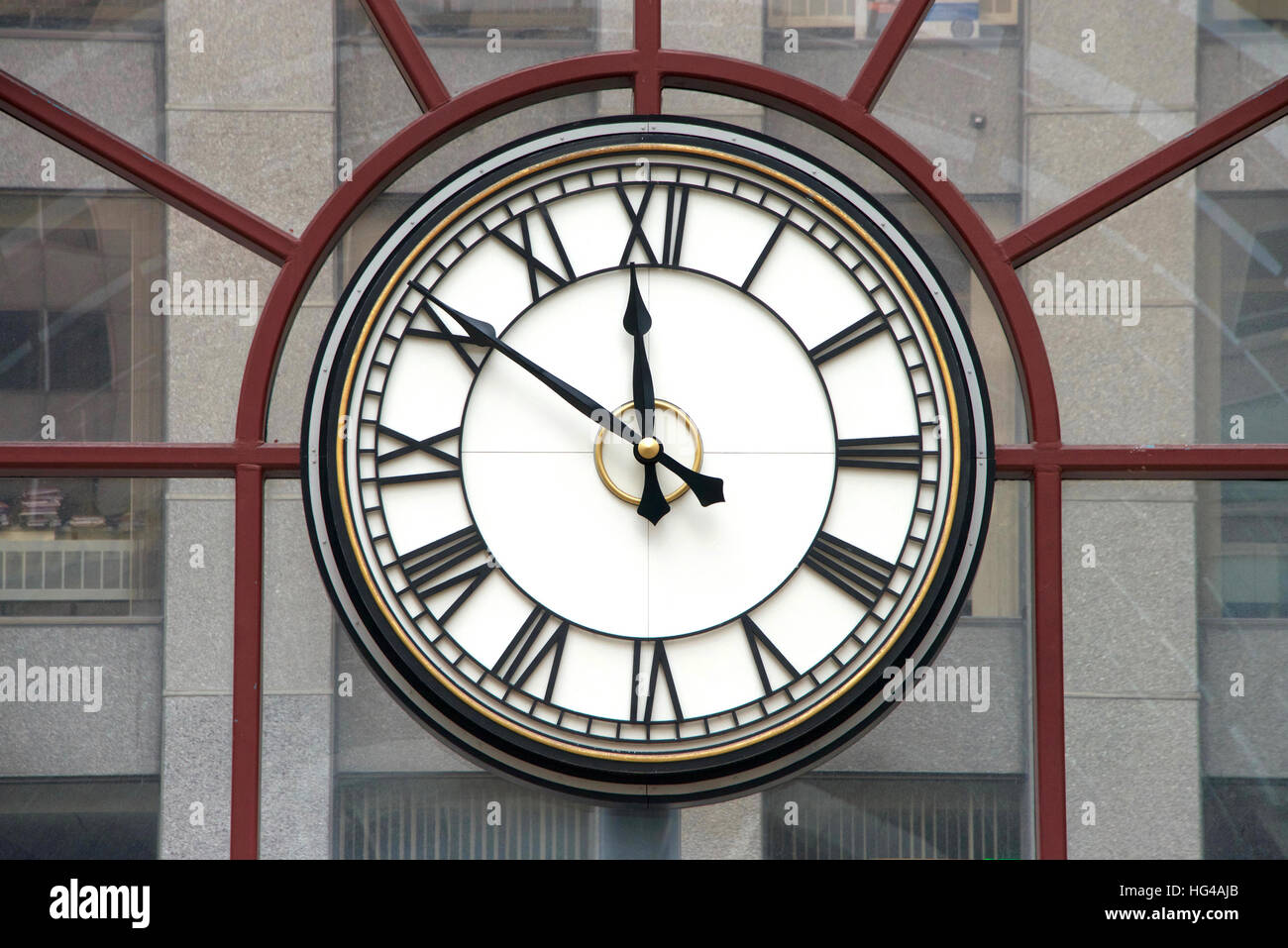 Clock with roman numerals for hours, hands at nine minutes to twelve o ...