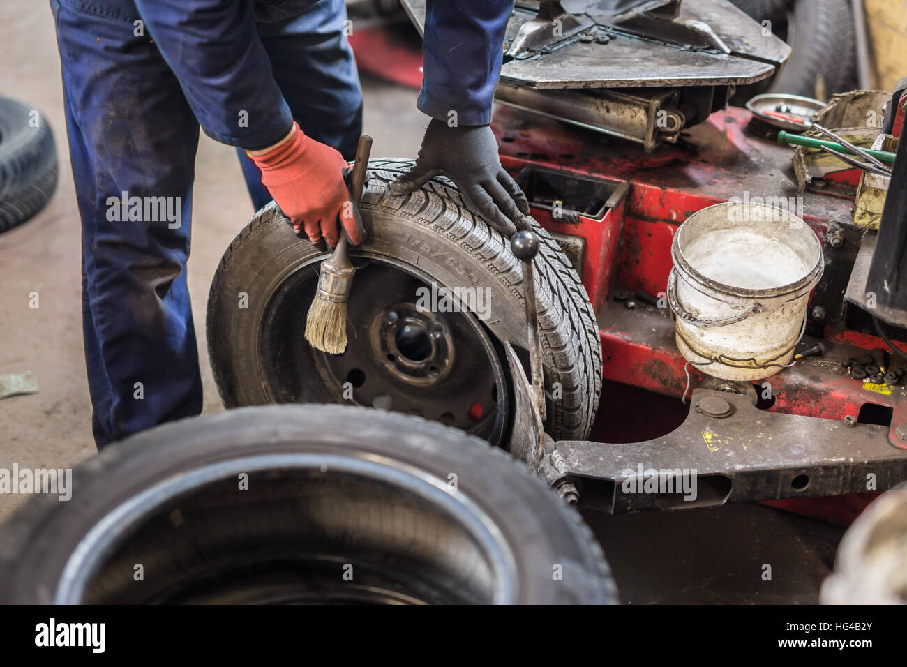 Professional auto mechanic replacing tire on wheel in car repair ...