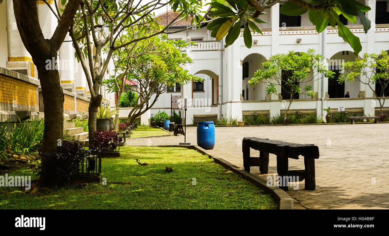a blue trash can and a wood bench at Lawang Sewu photo taken in ...