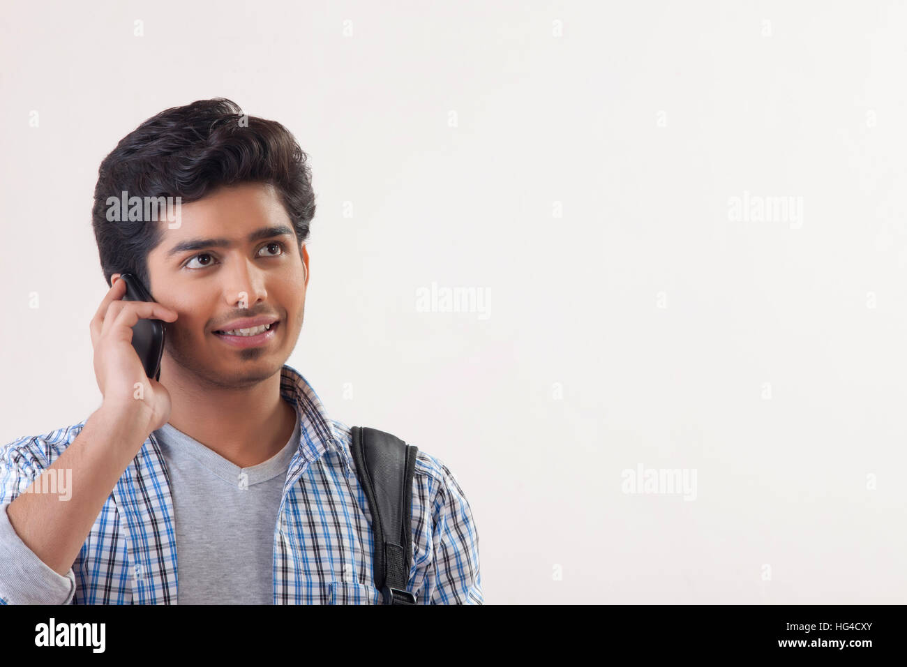 Smiling male college student using mobile phone Stock Photo - Alamy
