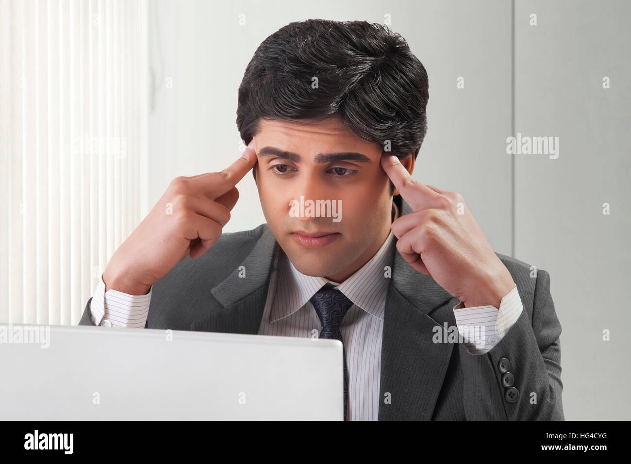 Tensed young businessman using laptop hi-res stock photography and ...