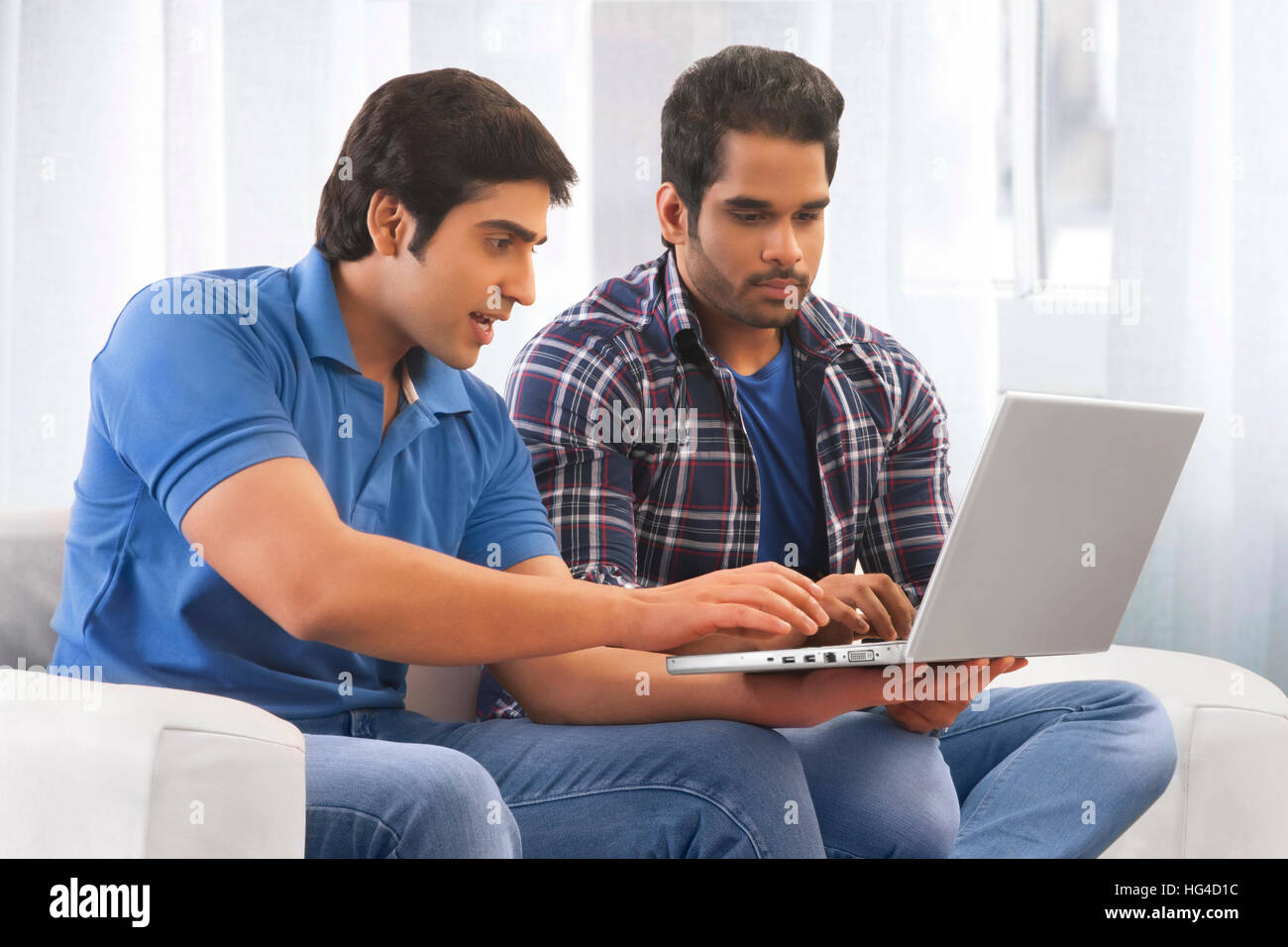 Two friends using laptop Stock Photo - Alamy