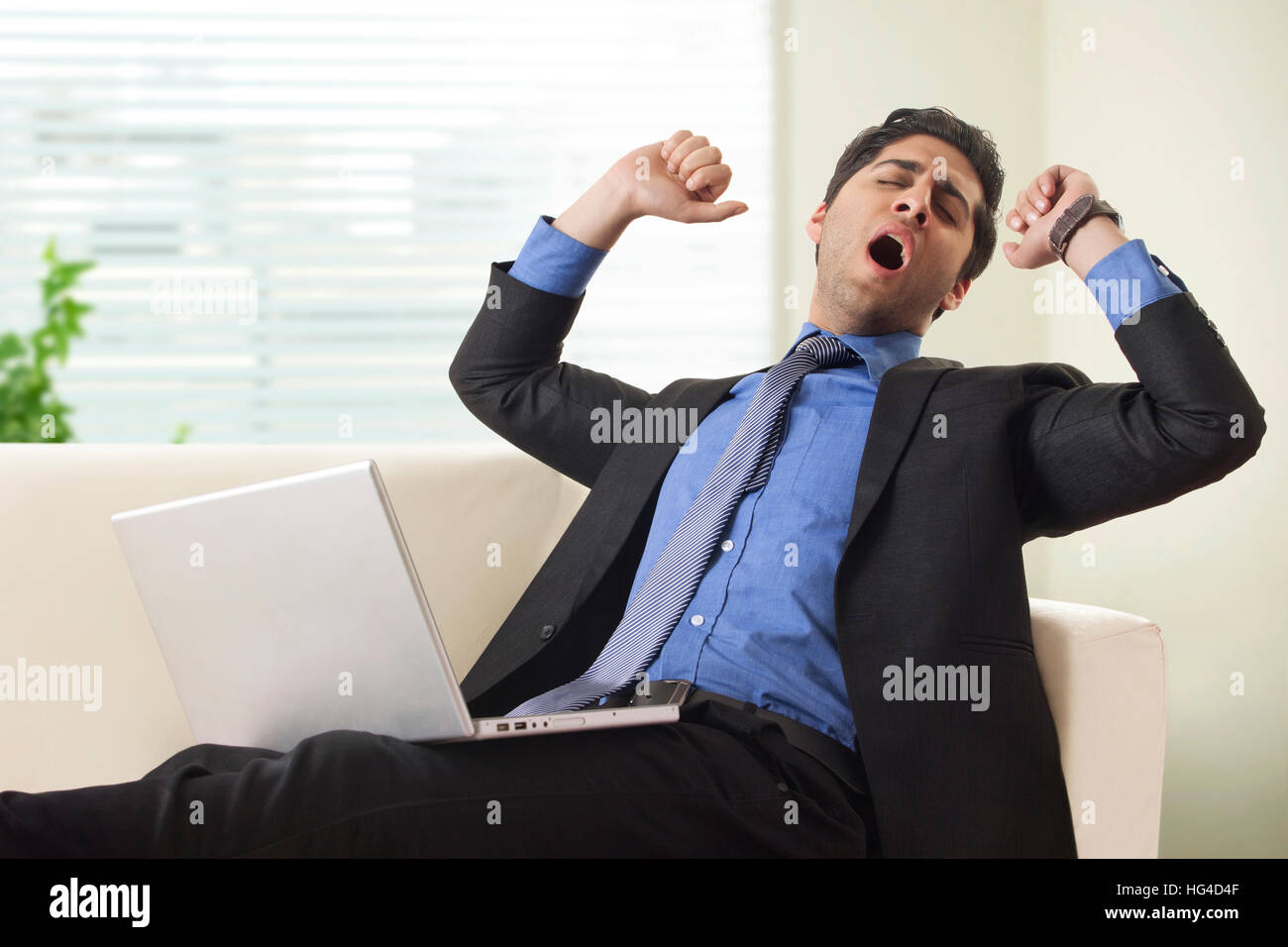 Young businessman yawning Stock Photo - Alamy