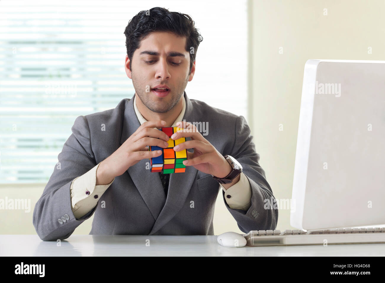 Businessman solving Rubik's Cube puzzle Stock Photo - Alamy