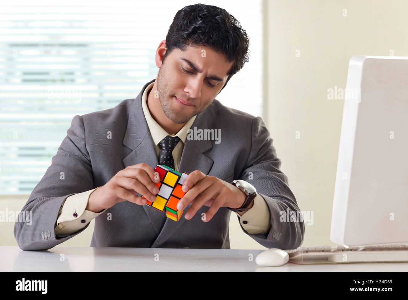 Businessman solving Rubik's Cube puzzle Stock Photo - Alamy