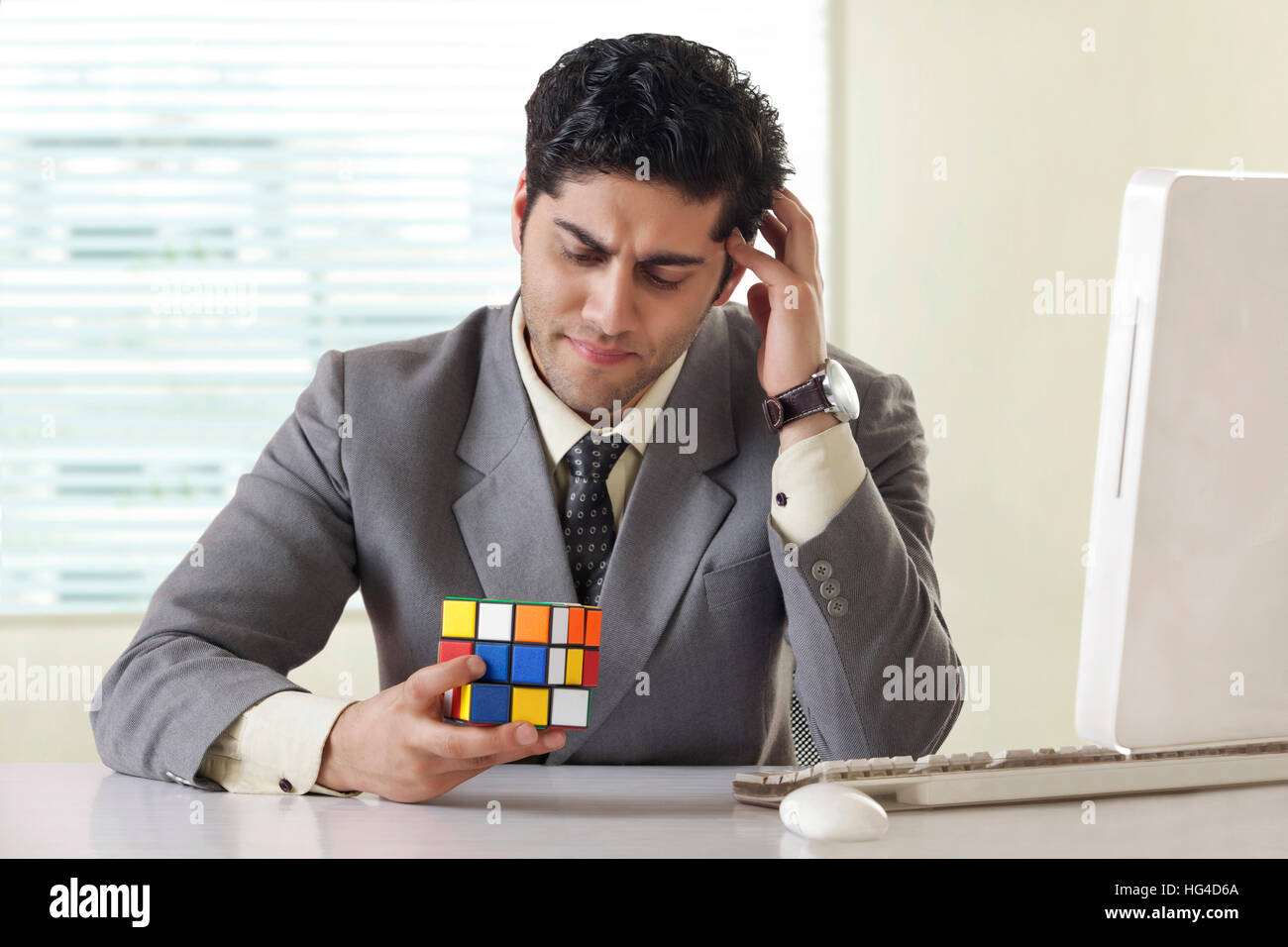 Businessman solving Rubik's Cube puzzle Stock Photo - Alamy