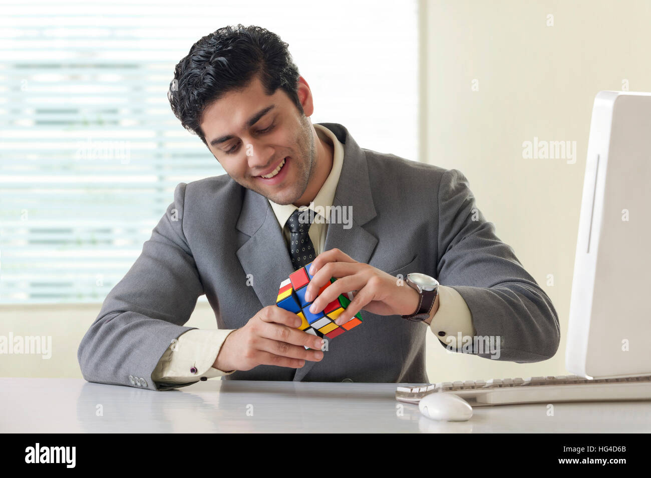 Businessman solving Rubik's Cube puzzle Stock Photo - Alamy