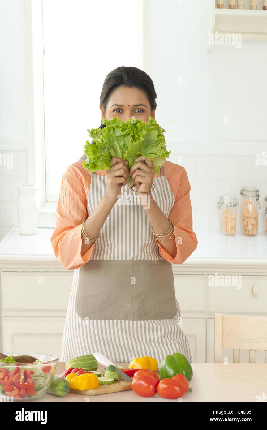 Woman covering her face with lettuce Stock Photo - Alamy
