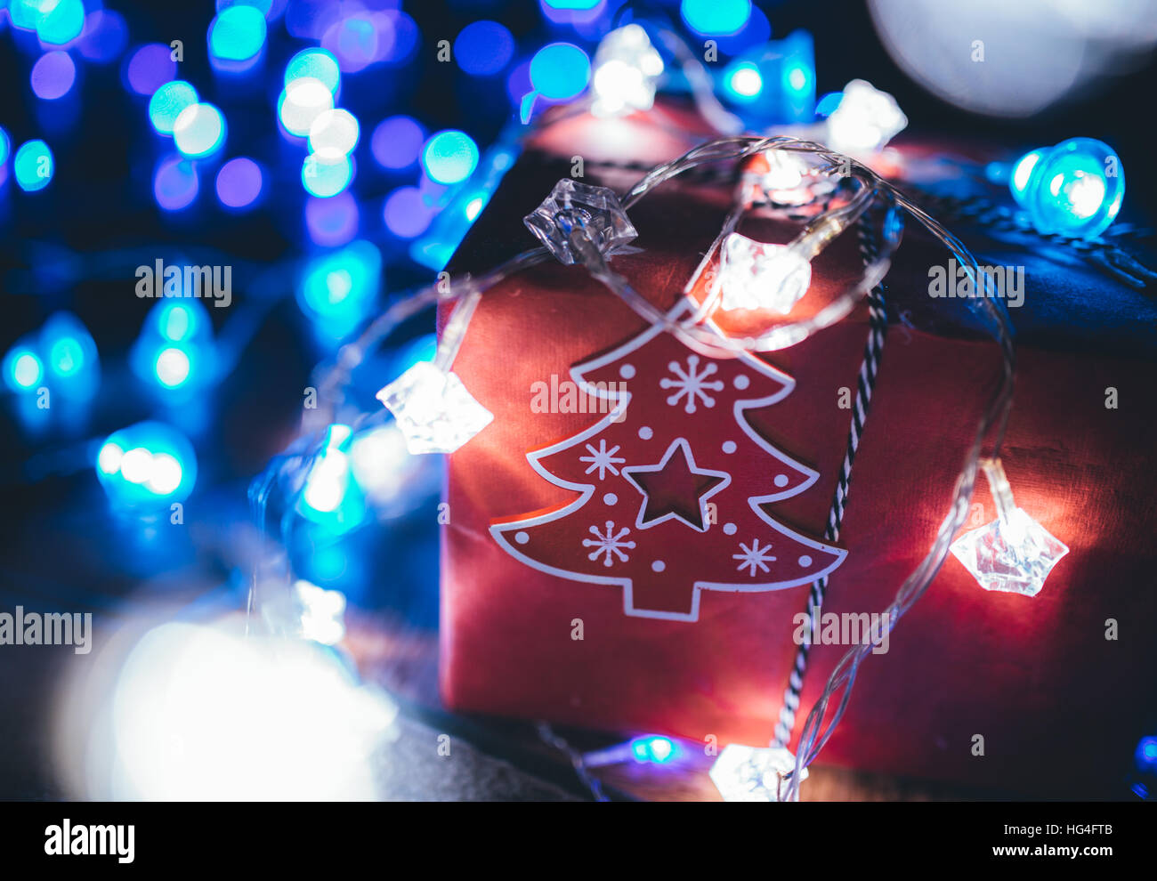 Christmas gift boxes with glowing garland and blue bokeh lights Stock Photo - Alamy