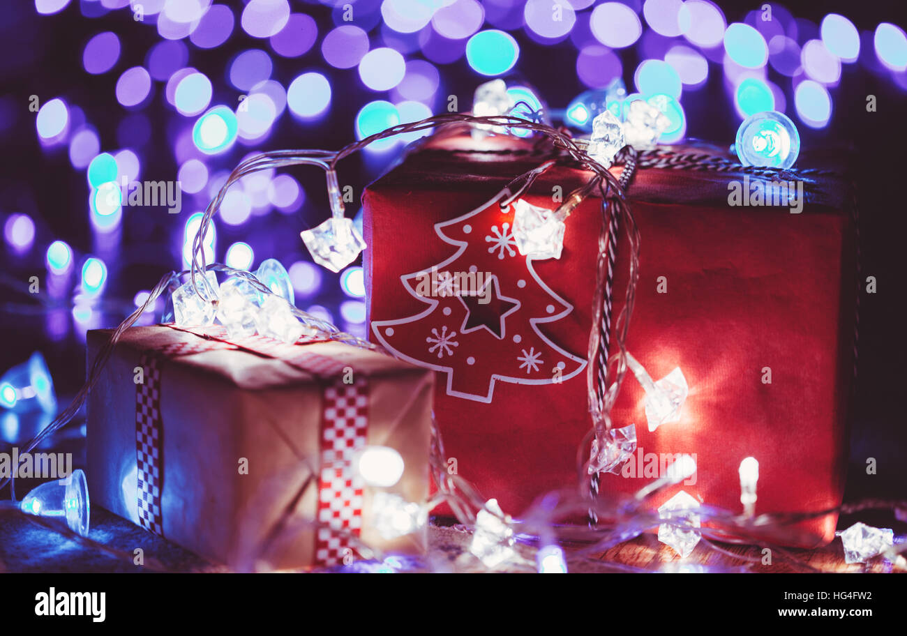 Christmas gift boxes with glowing garland and blue bokeh lights Stock ...