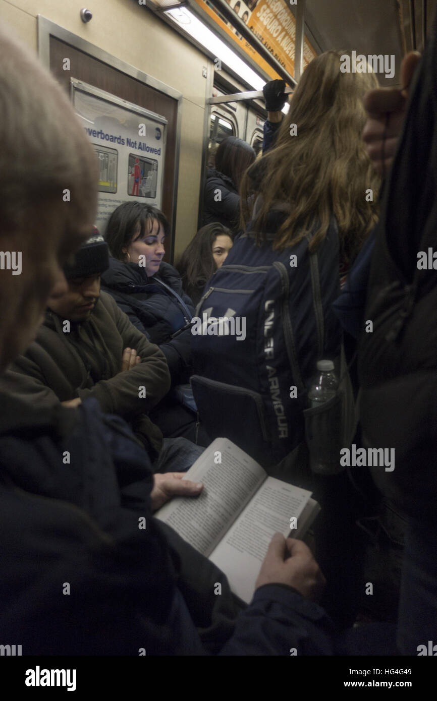 Man reading book on crowded subway hi-res stock photography and images ...