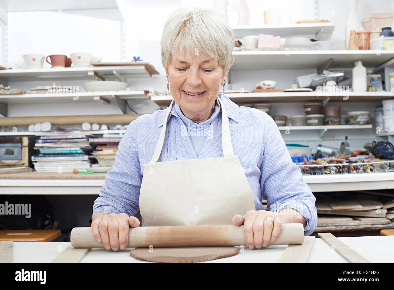 Senior Woman Rolling Out Clay In Pottery Studio Stock Photo - Alamy