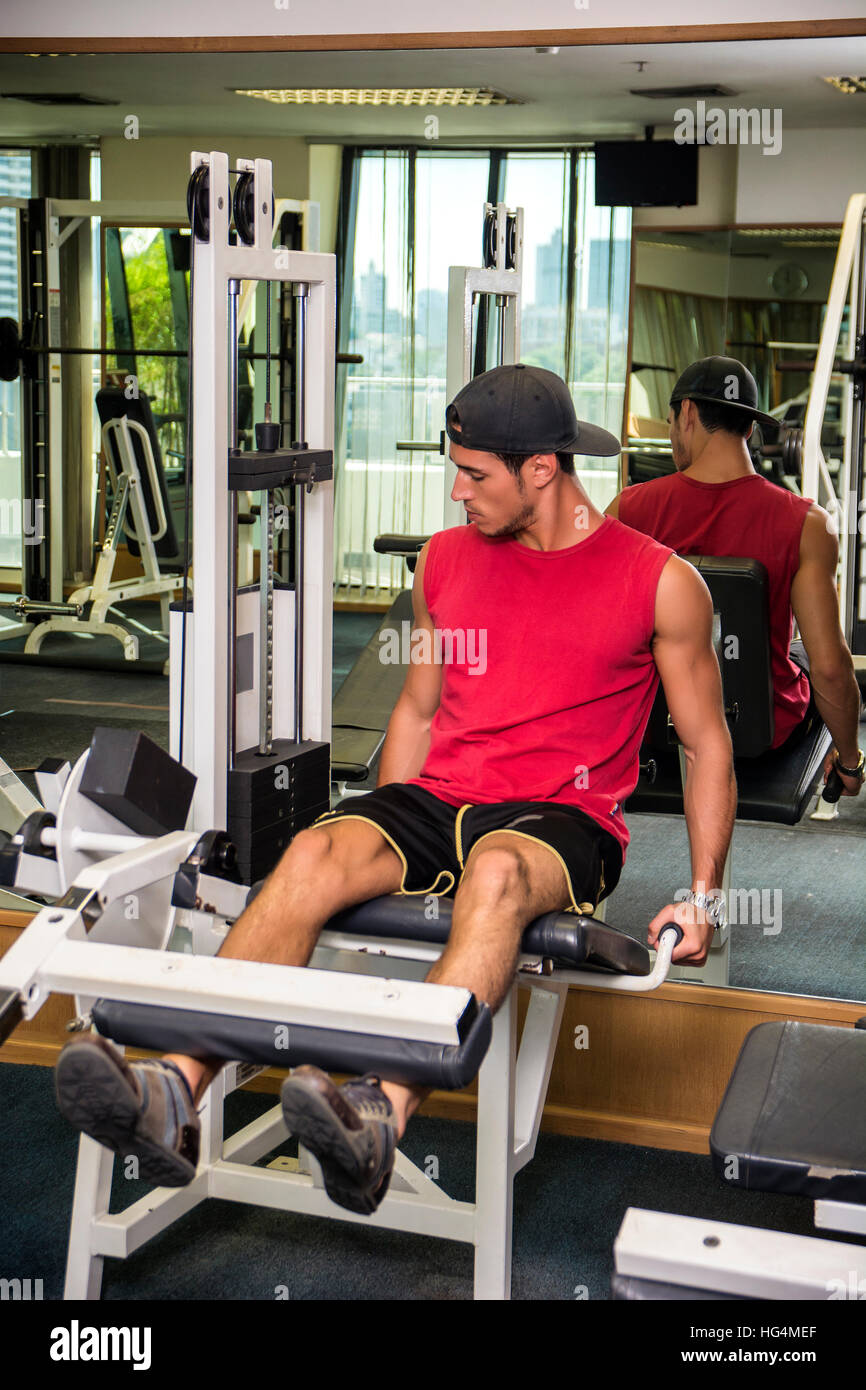 Handsome young man working out on gym equipment Stock Photo - Alamy