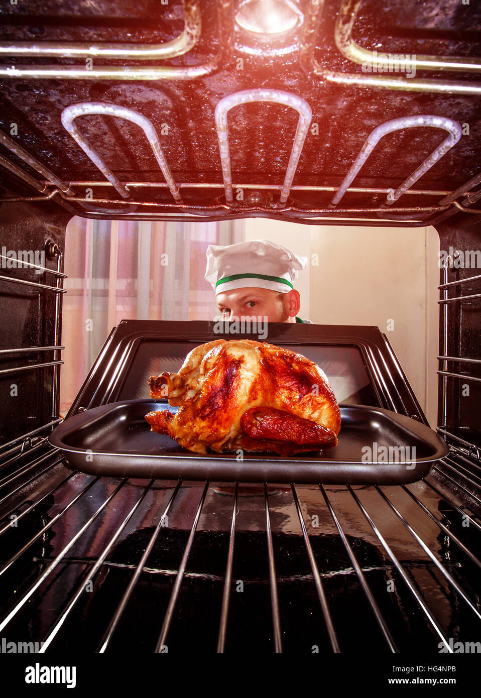 Chef prepares roast chicken in the oven, view from the inside of the ...