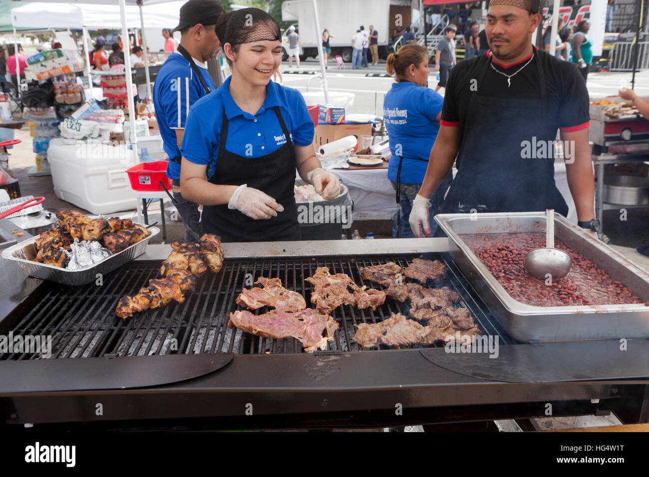 Latino woman cooking meat on barbecue grille at an outdoor event - USA ...