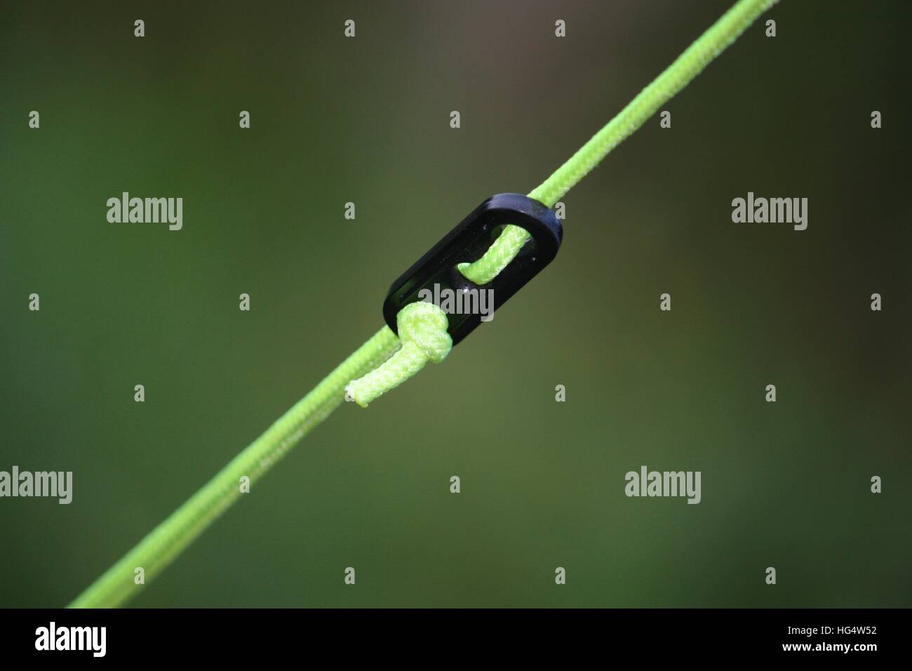 yellow guy rope with black plastic adjuster for a tent Stock Photo - Alamy