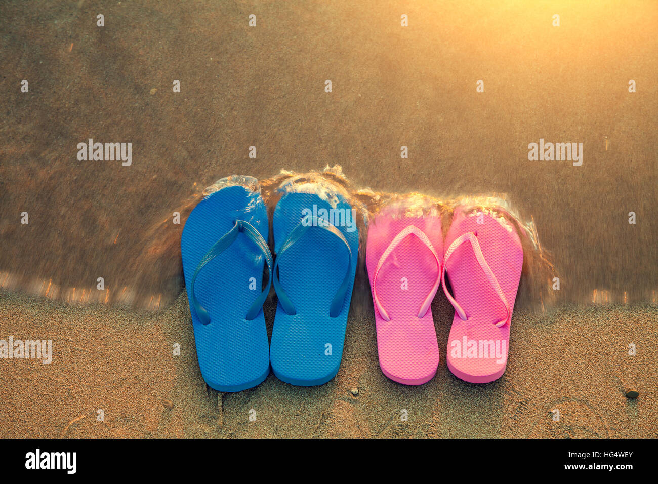 Romantic beach scene. Female and male flip flop sandals on the beach at ...