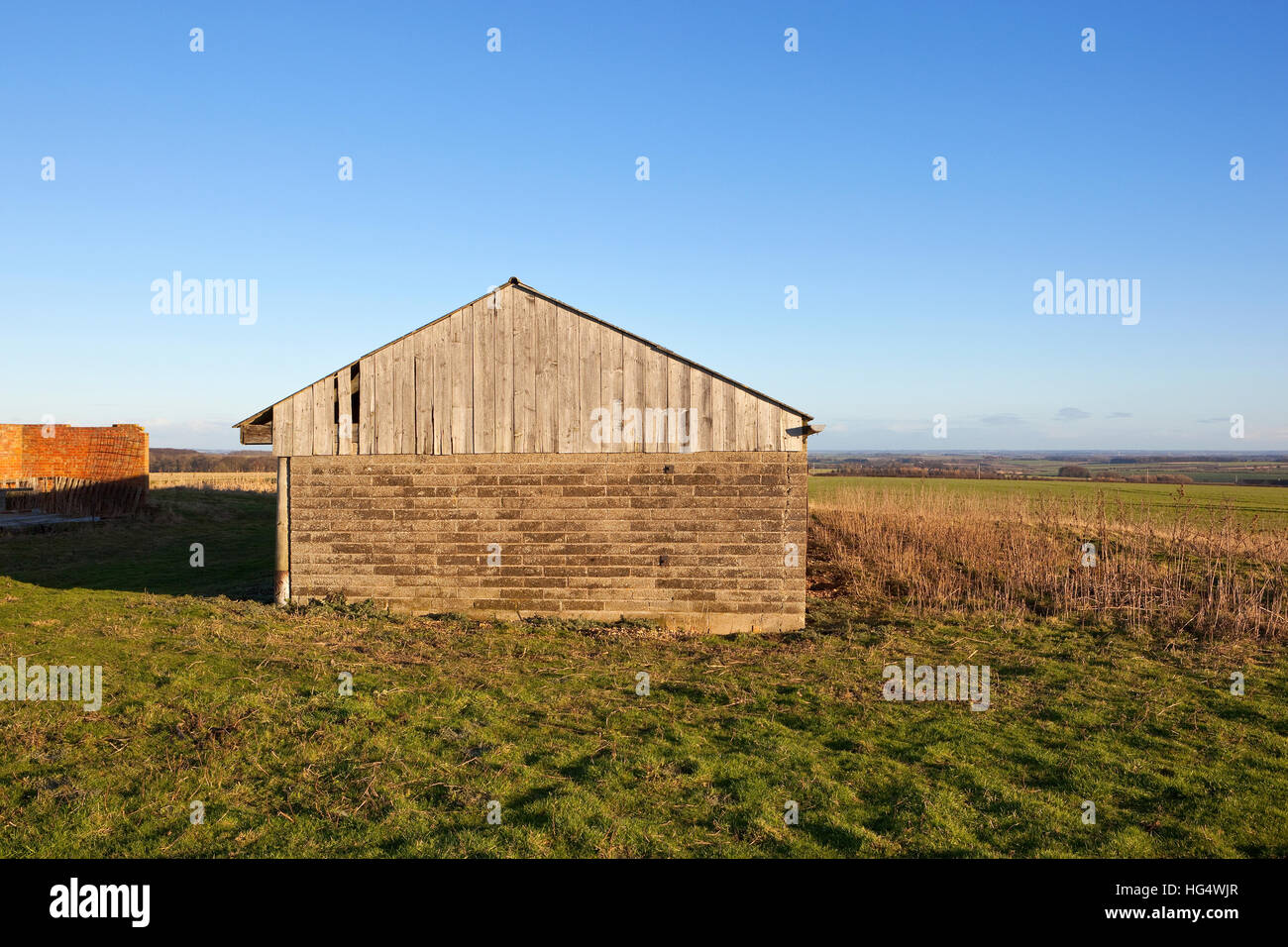A wood and stone barn high on the farmland of the Yorkshire wolds under ...