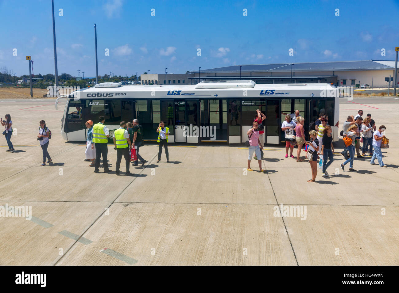Passengers get off the bus in the Paphos International Airport. It is ...
