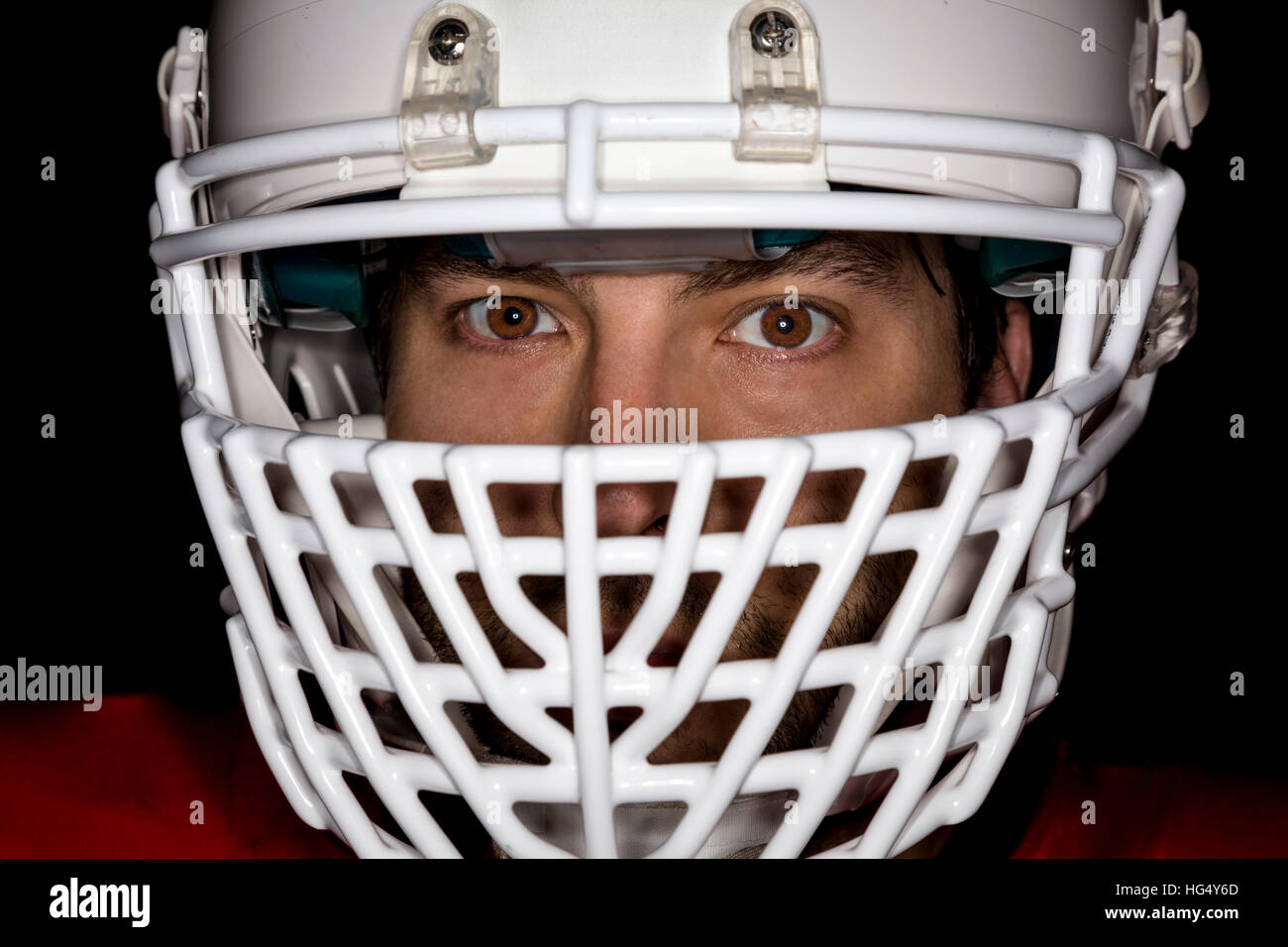 Close up in the eyes of a Football Player with a red uniform on a white ...
