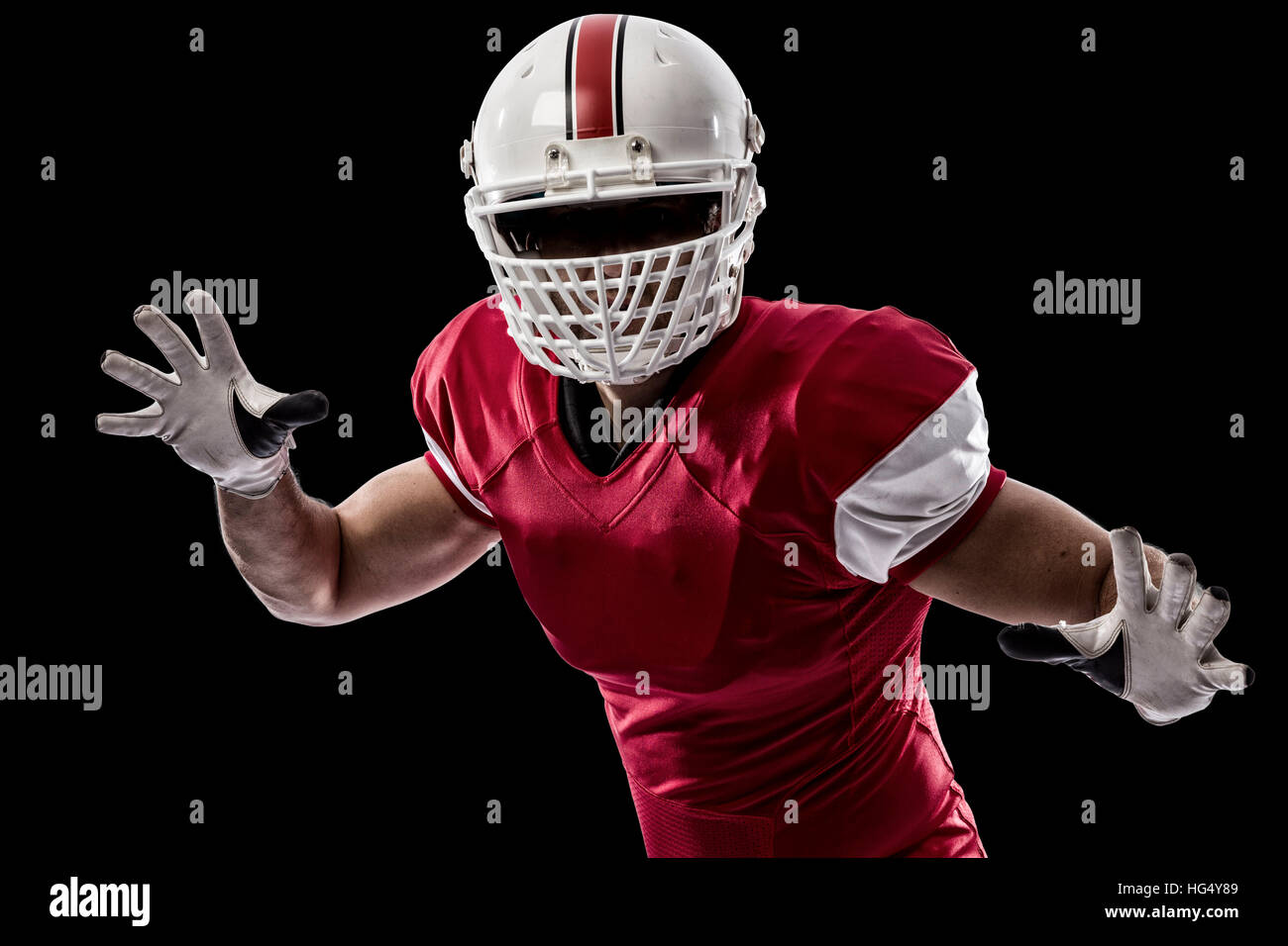 Football Player with a red uniform making a tackle on a Black ...