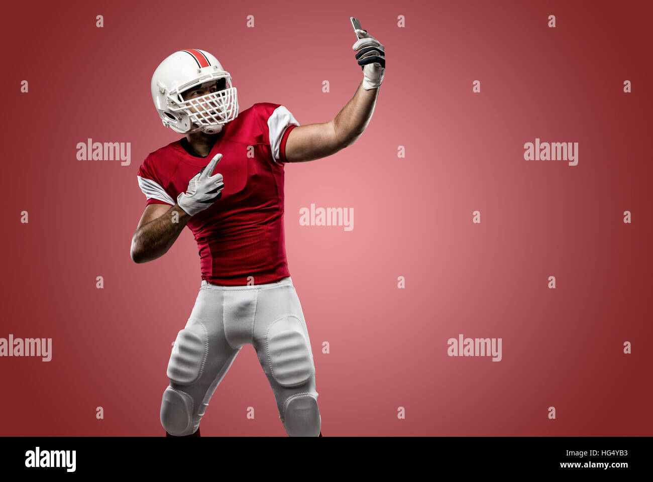 Football Player with a red uniform making a selfie on a red background ...
