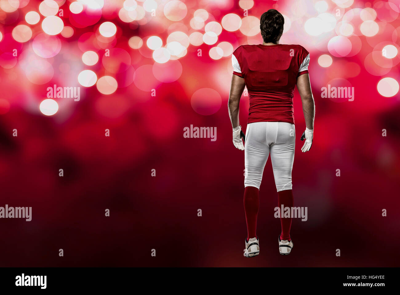 Football Player with a red uniform walking, showing his back on a red ...