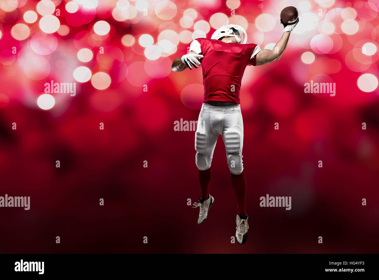 Football Player with a red uniform making a catch on a red lights ...