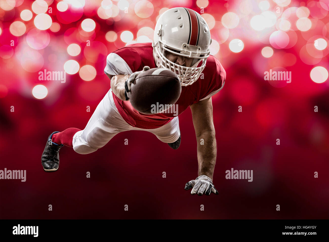 Football Player with a red uniform scoring on a red lights background ...