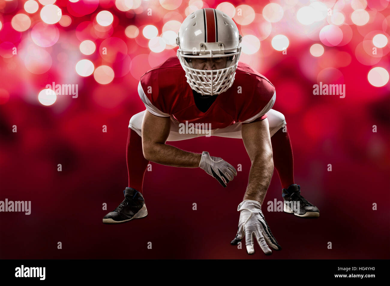 Football Player with a red uniform on the scrimmage line, on a red ...