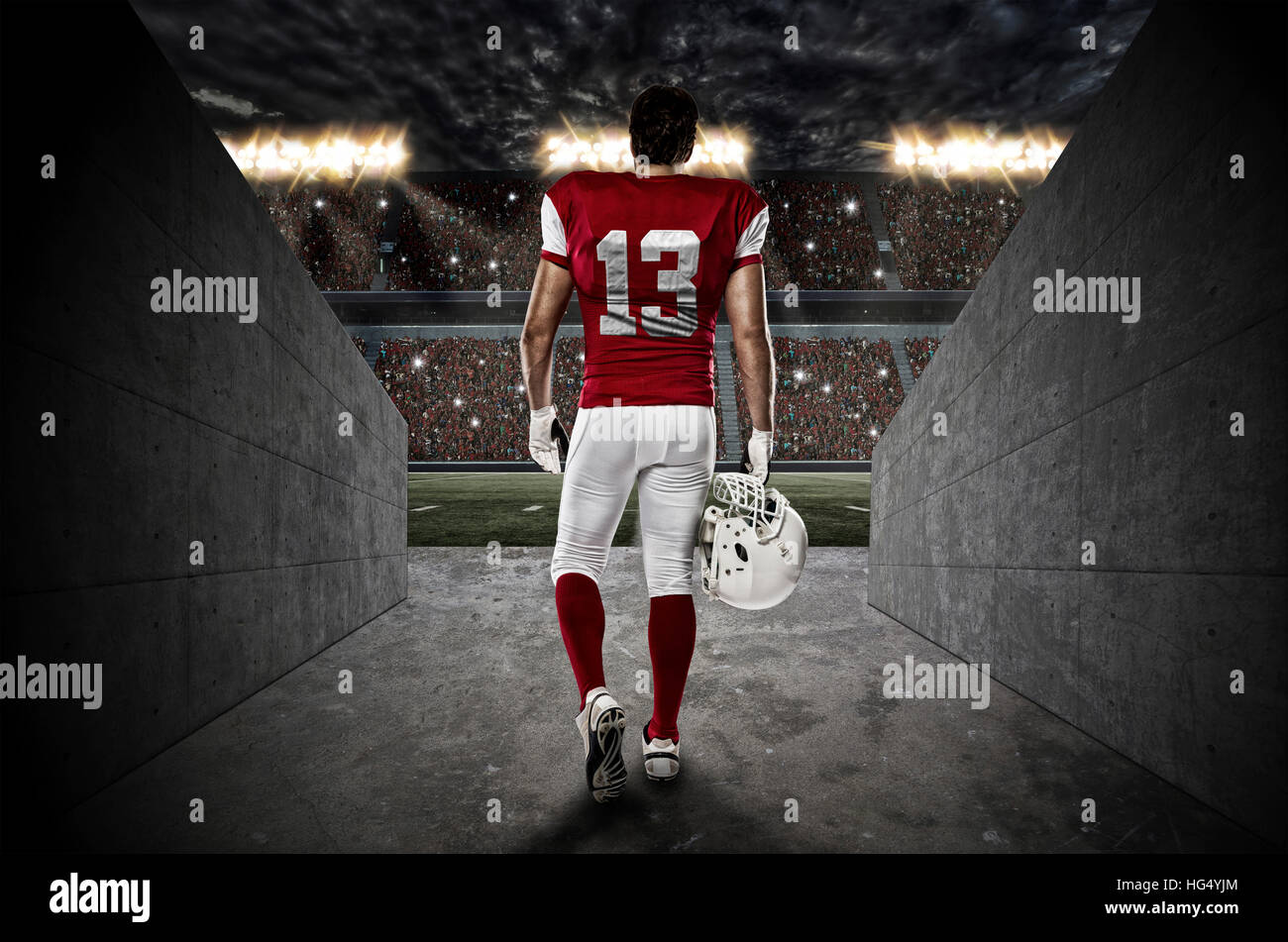 Football Player with a red uniform walking out of a Stadium tunnel ...