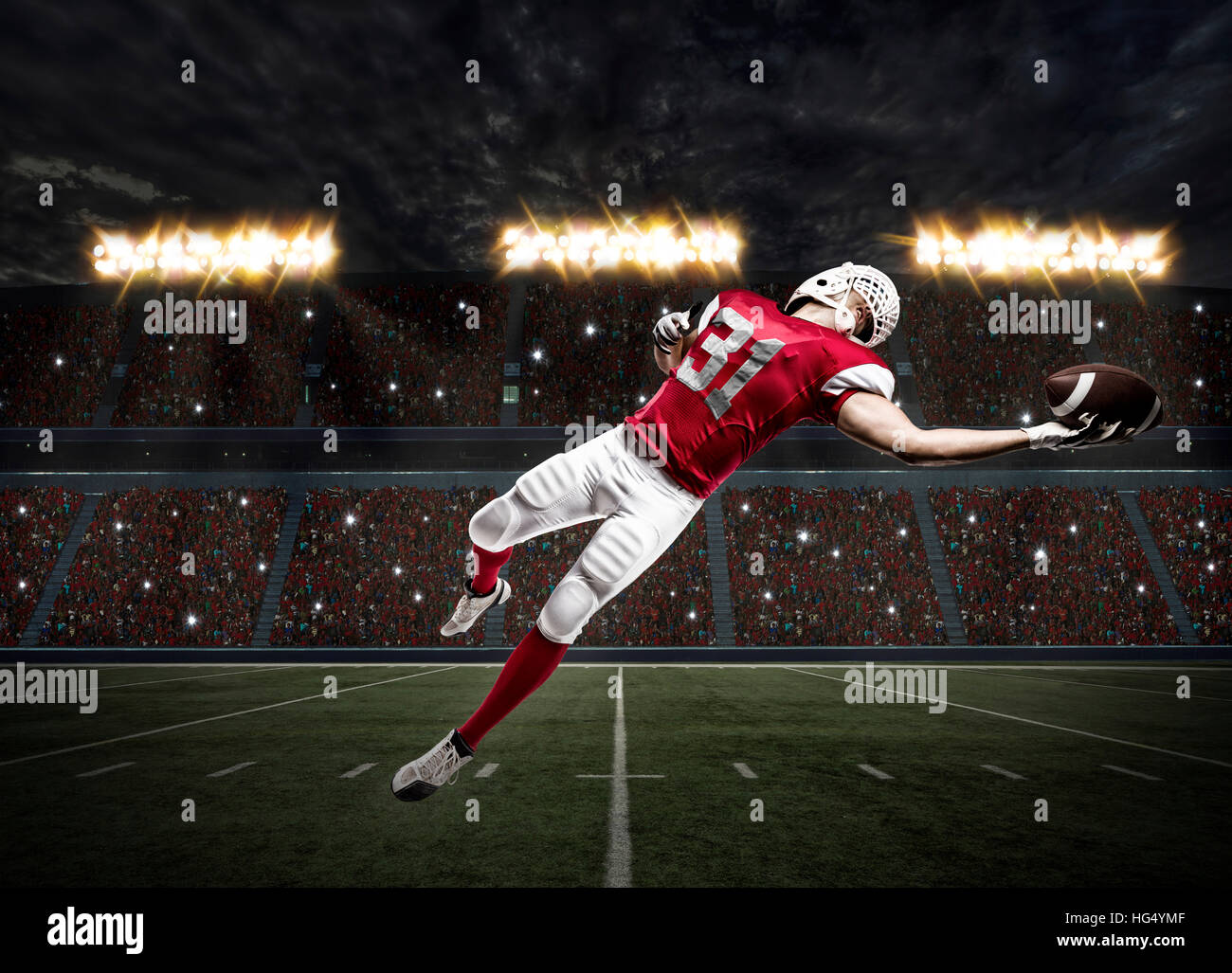 Football Player with a red uniform catching a ball on a stadium Stock ...