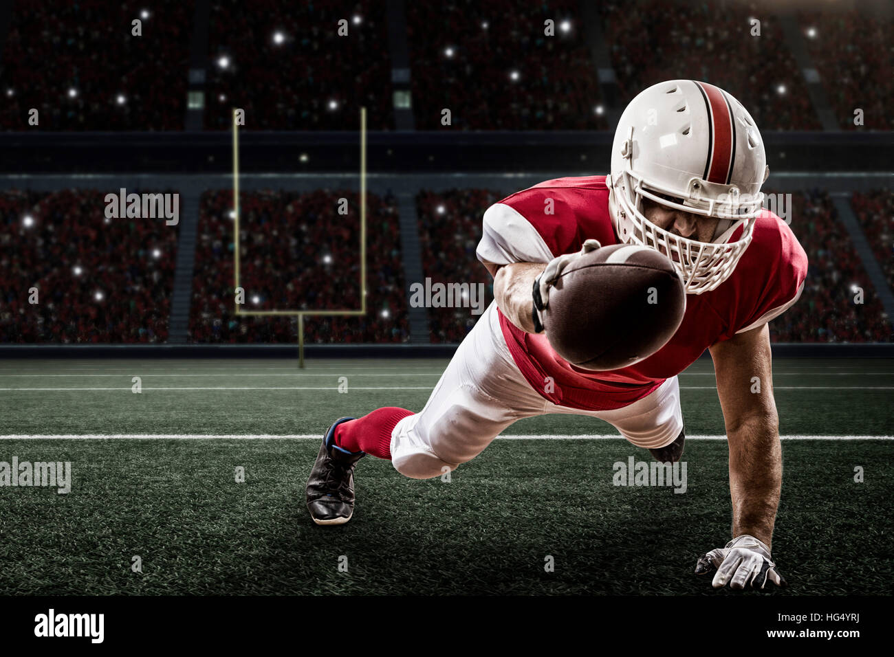 Football Player with a red uniform scoring on a Stadium Stock Photo - Alamy