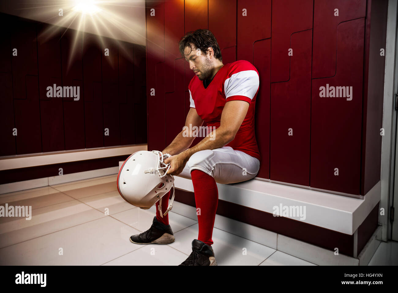 Football Player with a red uniform seated in locker room Stock Photo ...