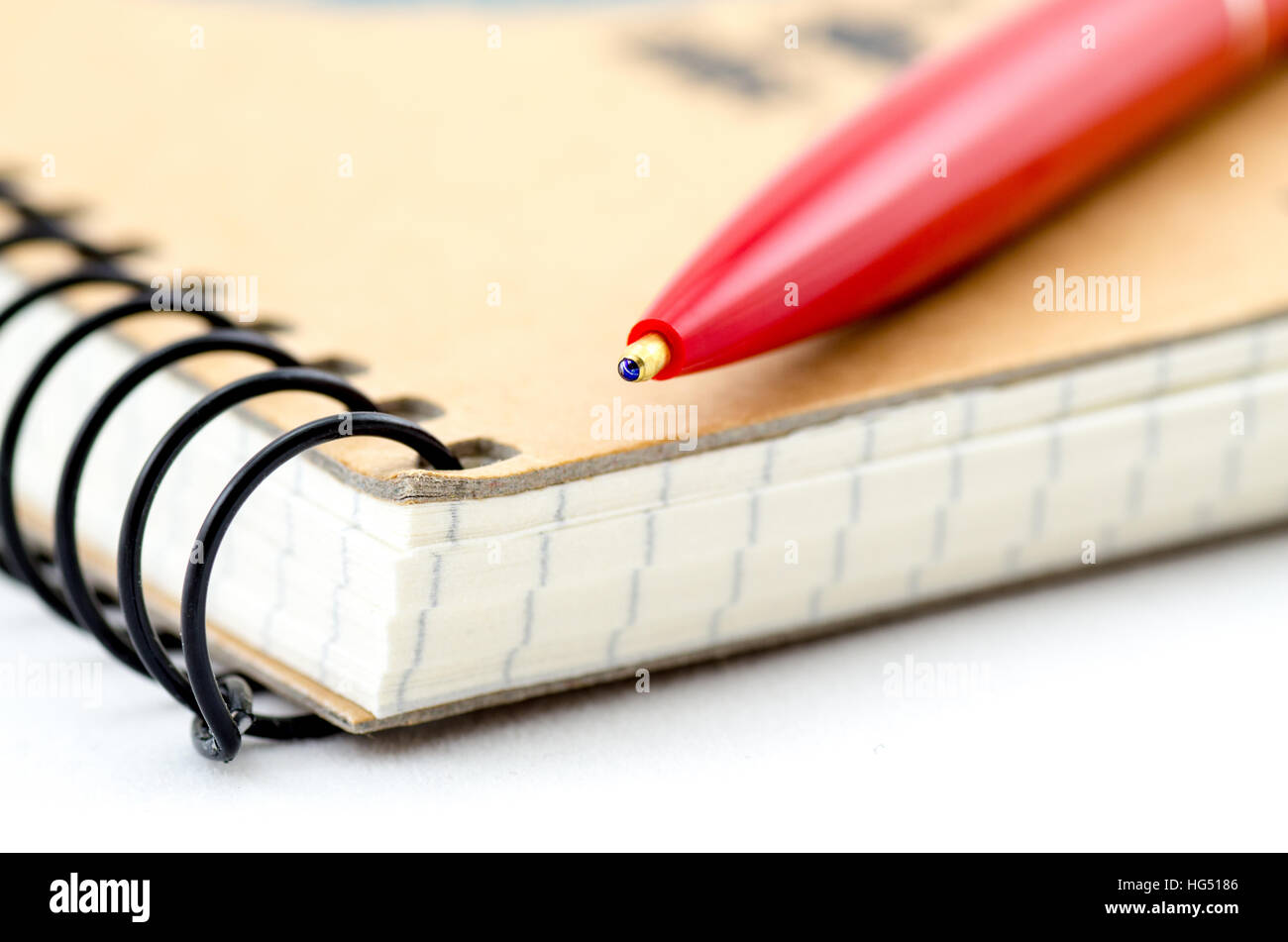 Close up notebook corner and red pencil Stock Photo - Alamy